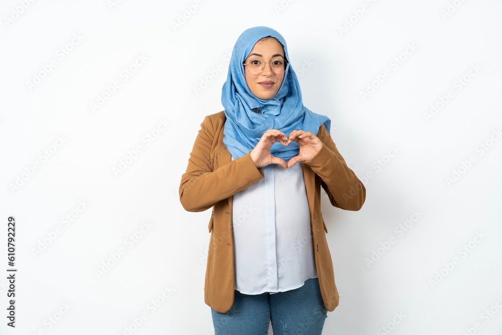 Serious Young beautiful pregnant muslim woman wearing hijab over white ...