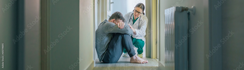 Female doctor assisting and comforting to male patient with mental ...