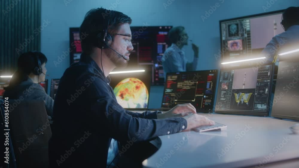 Flight control worker in headset monitors space mission with astronaut ...