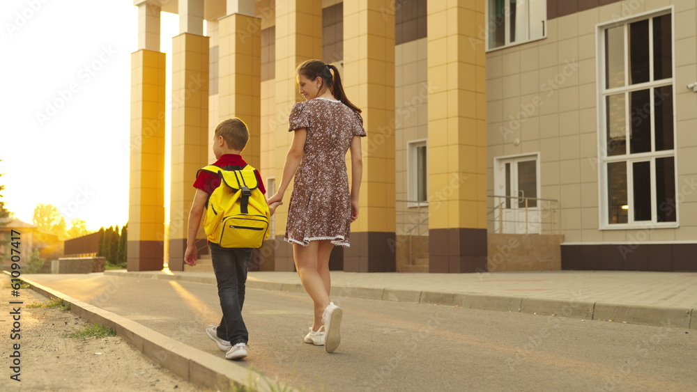 Foto de mother holding hand little son first grader going school rays ...
