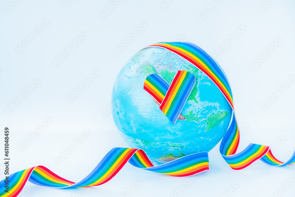 Earth globe model with LGBT rainbow ribbon and heart on the white ...