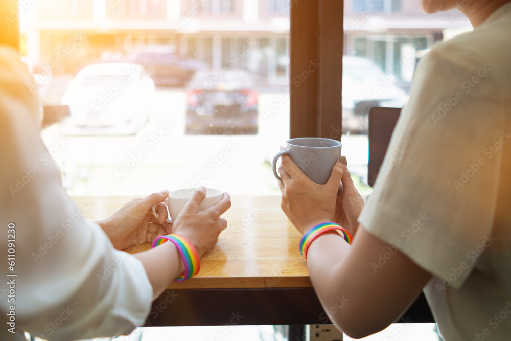 young woman lgbtq couple is having coffee at window counter inside ...