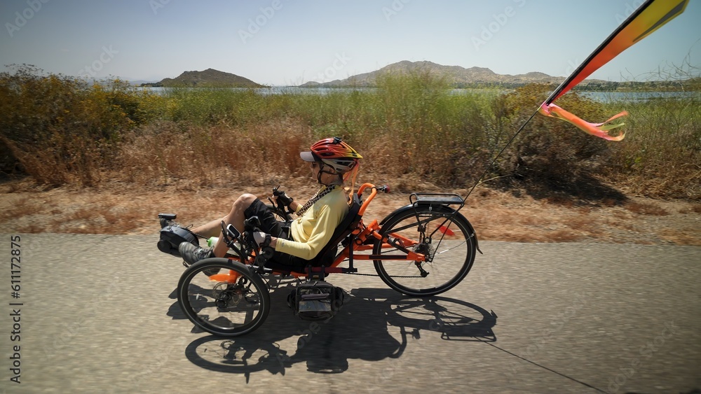 Side view of elderly senior woman riding recumbent e-bike electric ...