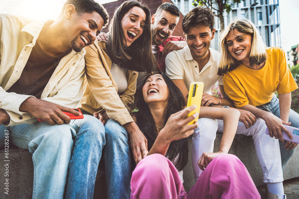 Millennial group of people using smart mobile phone device outdoors - Happy multiracial ...