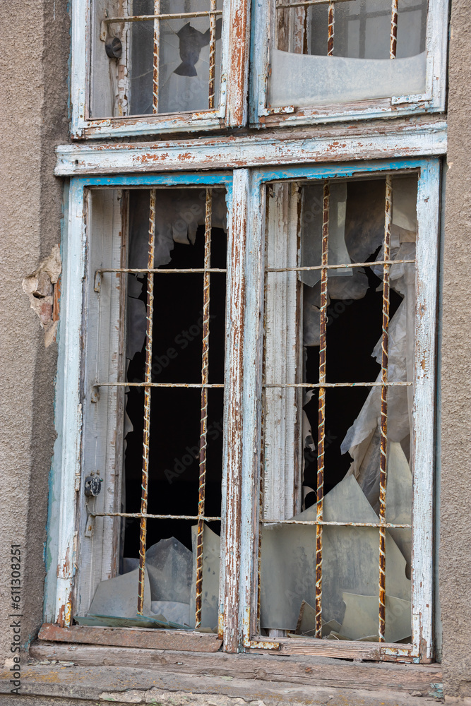 Old window with worn wooden shutters on exterior wall of an old ruined ...