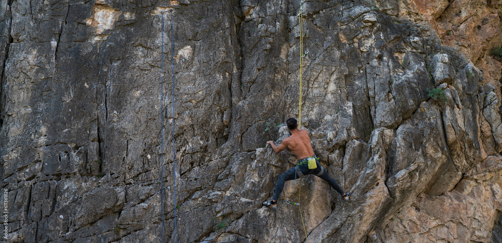 View from behind of a young male rock climber. Powerful male rock ...