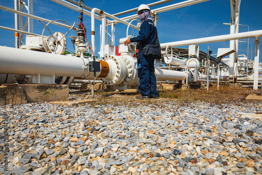 Production operator opening ball valve at pipeline oil and gas wellhead ...