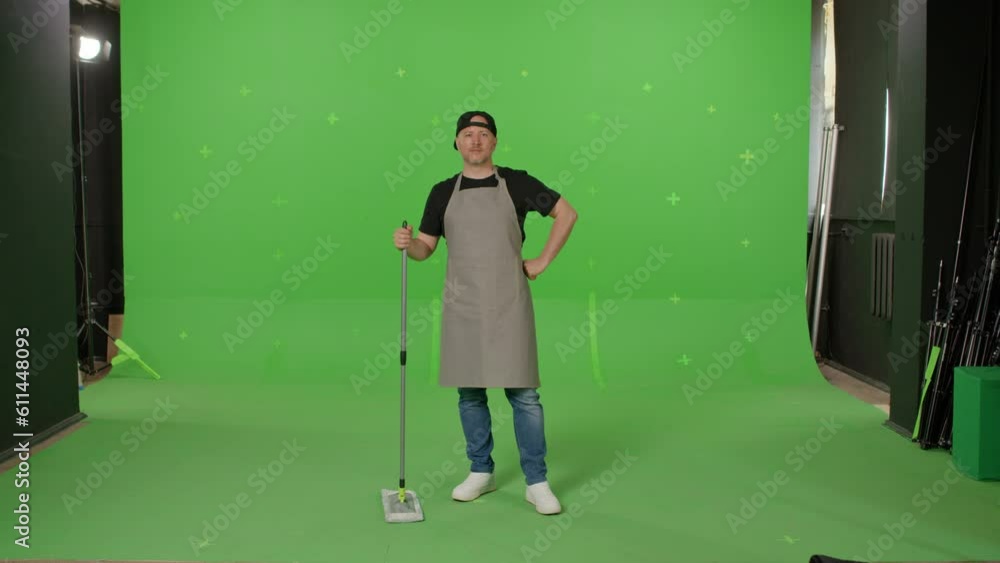 the waiter standing with a mop in his hands on green screen chroma key ...