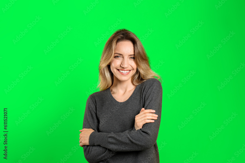 Chroma key compositing. Pretty young woman smiling against green screen ...