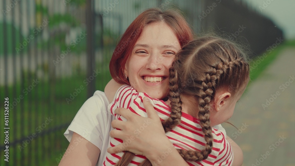 Child, daughter runs to mom hugs her in park on street in spring. Happy ...