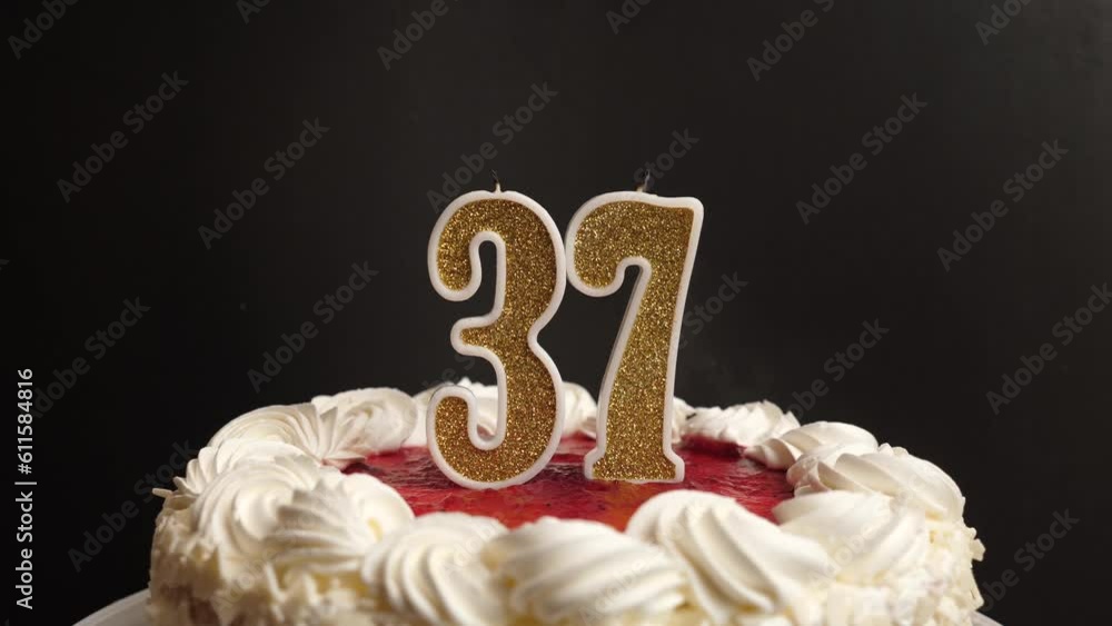 A candle in the form of the number 37, inserted into the holiday cake ...