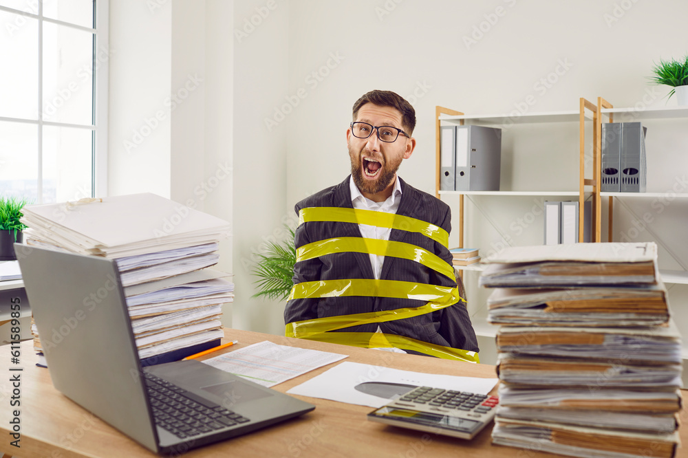 Funny young man, stuck at work in office and bound with yellow scotch ...