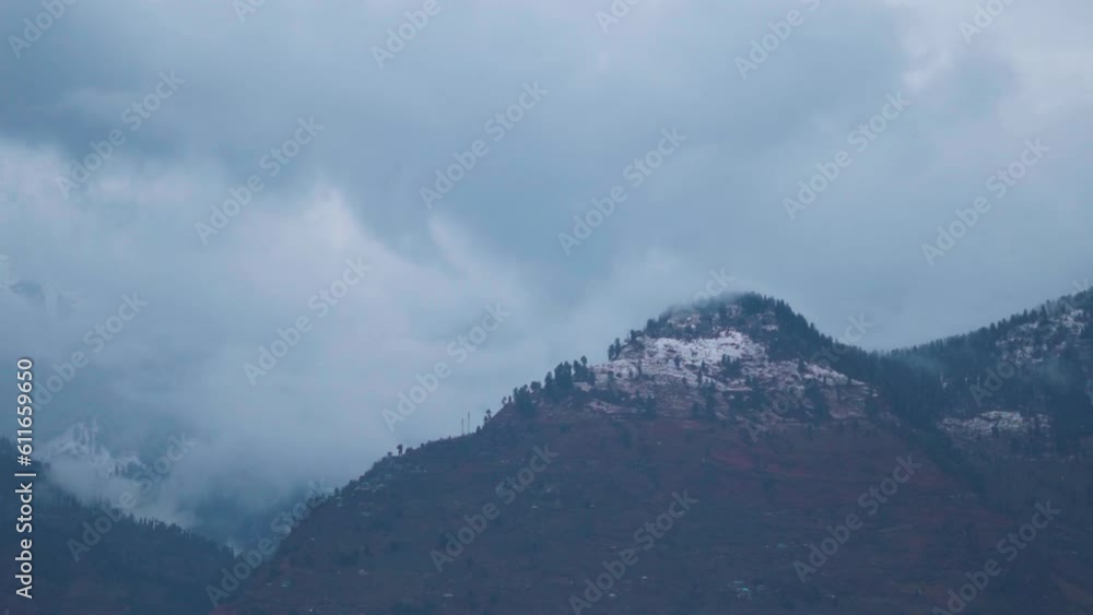 Clouds above the snow covered Himalayan mountain peaks of Kullu valley ...