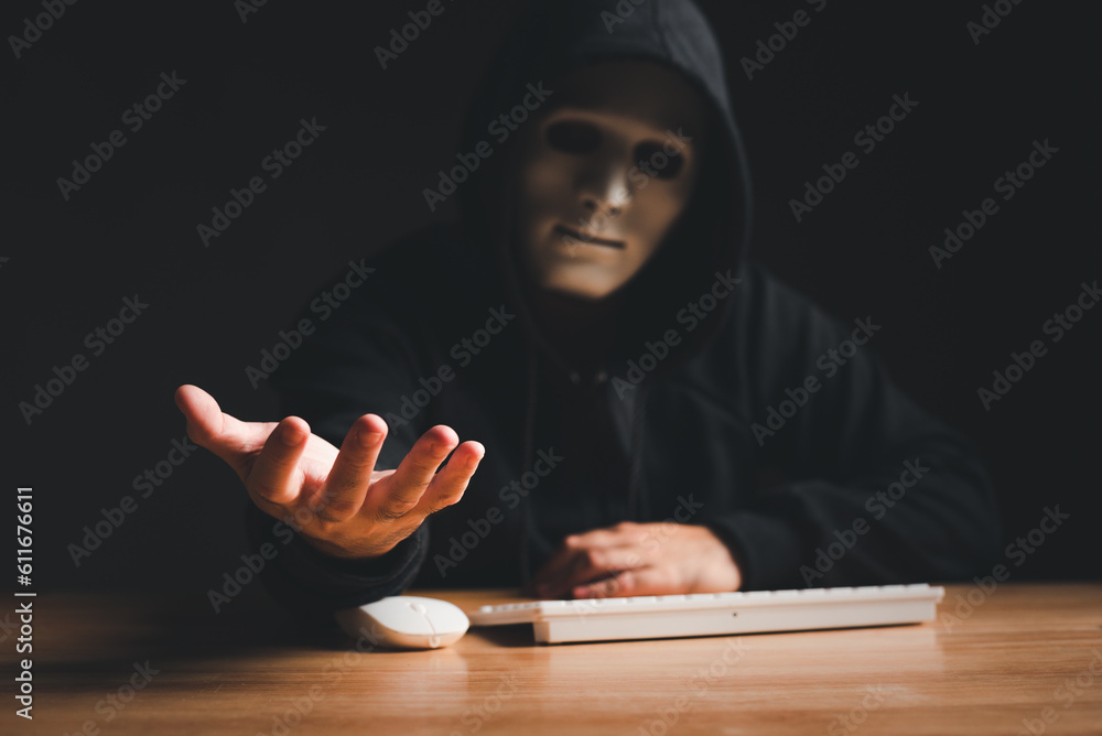 Black hat hacker force demands ransom by holding out his hand on table ...