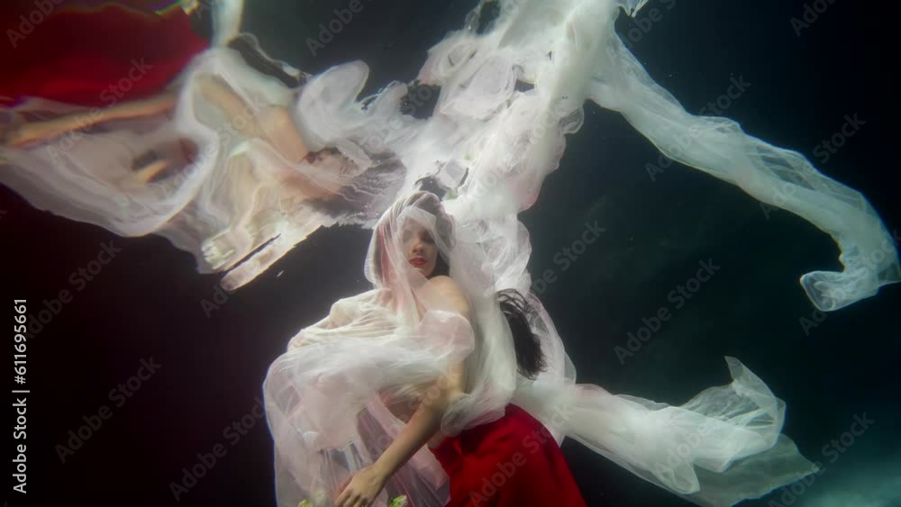 attractive fashion model floating underwater, mysterious female figure ...