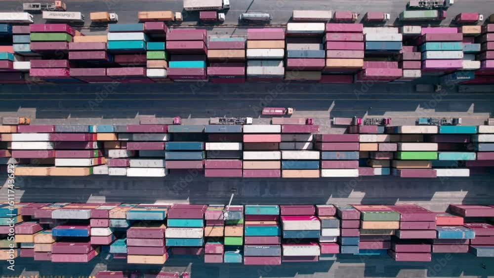 Trucks and cars driving between stacked cargo containers top down ...