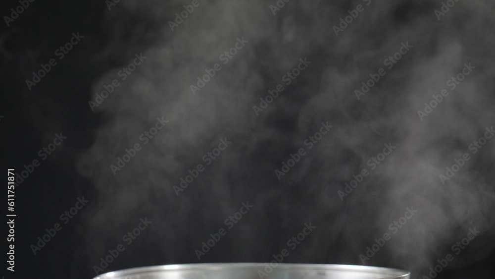 Vidéo Stock Steam comes out of pan while cooking. Boiling water in pan ...