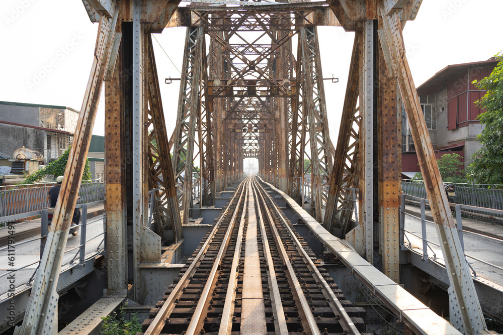 Vintage steel train bridge at Long Bien railway through a river in ...