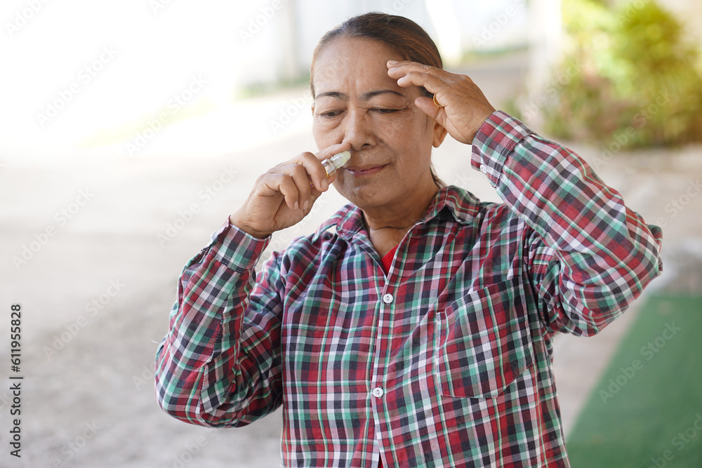 Asian senior woman feels dizzy, going to faint, smells Thai herbal ...