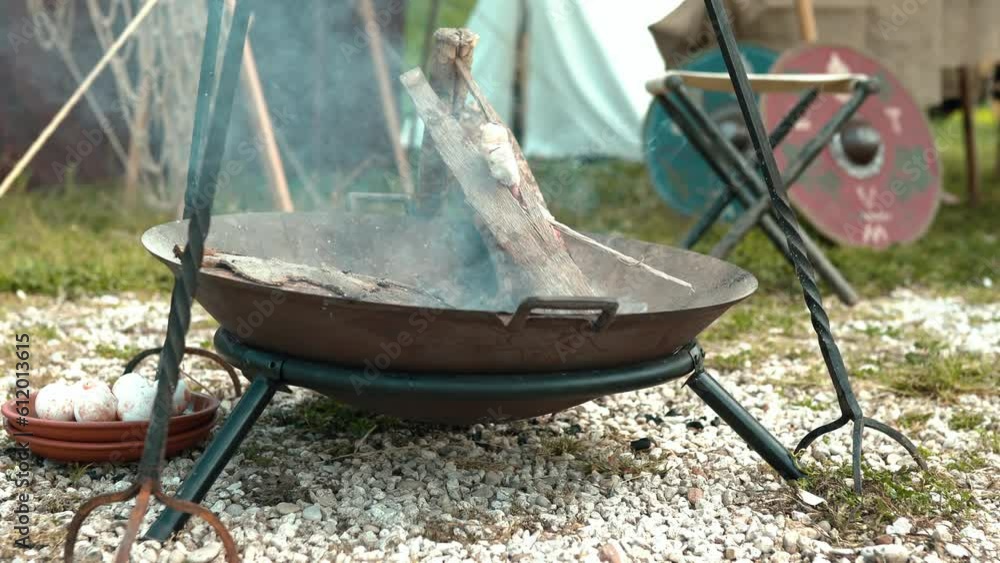 Cooking process in Roman military camp, round cauldron with burning ...