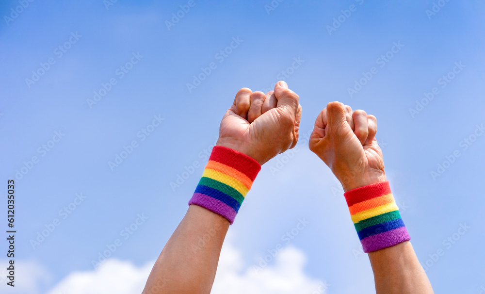 man hands wears lgbtq colorful rainbow wristband doing hand fist up ...