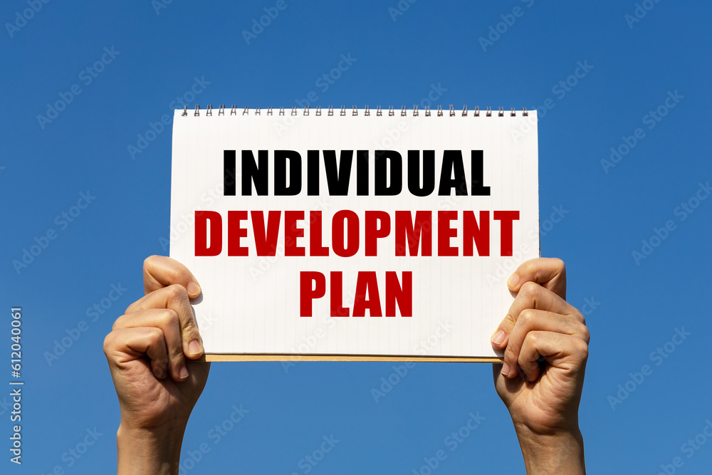 Individual development plan text on notebook paper held by 2 hands with ...