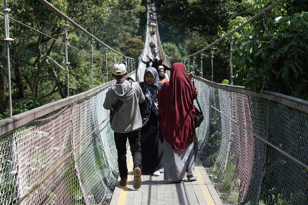 tourists walk at Rengganis suspension bridge which is the longest at ...