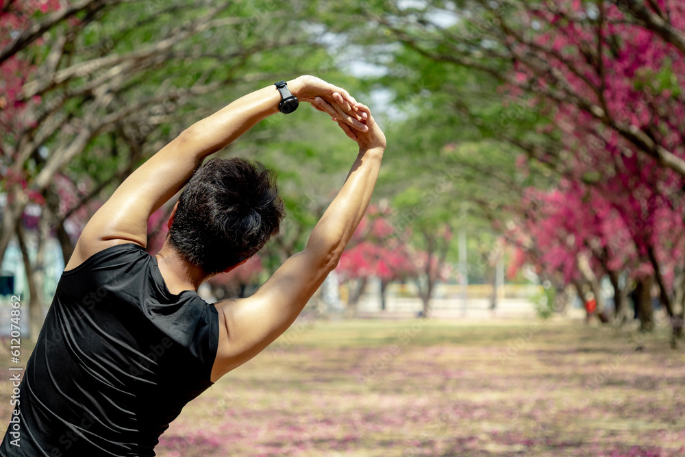 Asian athlete man with well trained body in black sportswear stretching ...