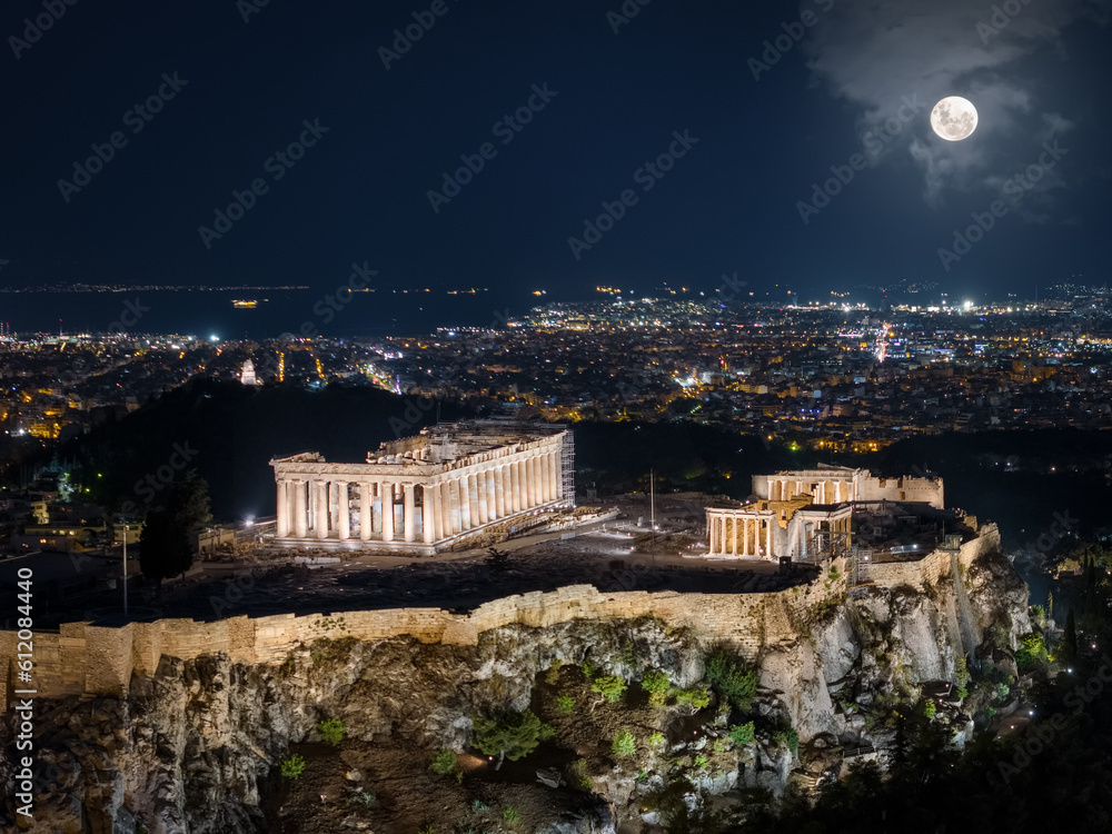 Aerial view of the illuminated Parthenon Temple at the Acropolis of Athens, Greece, during night ...