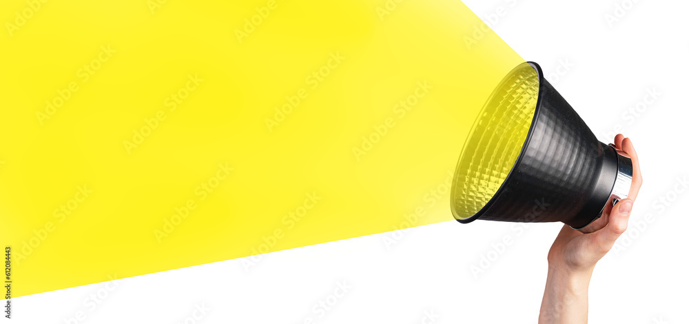 Hand holding bull horn, loud speaker with yellow light beam from it ...