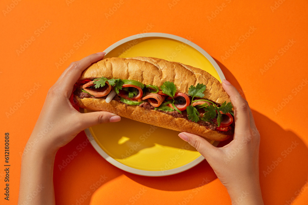 Female hands are holding the ends of the bread and prepare to lift it ...