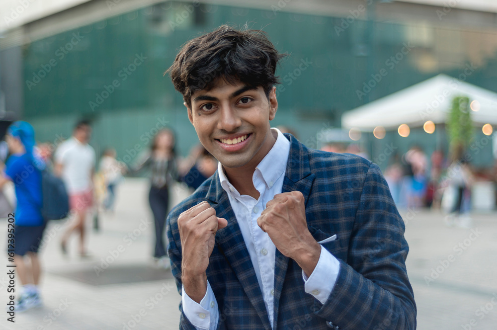 A stylish guy in a blue checkered suit, smiling with arms up in a ...