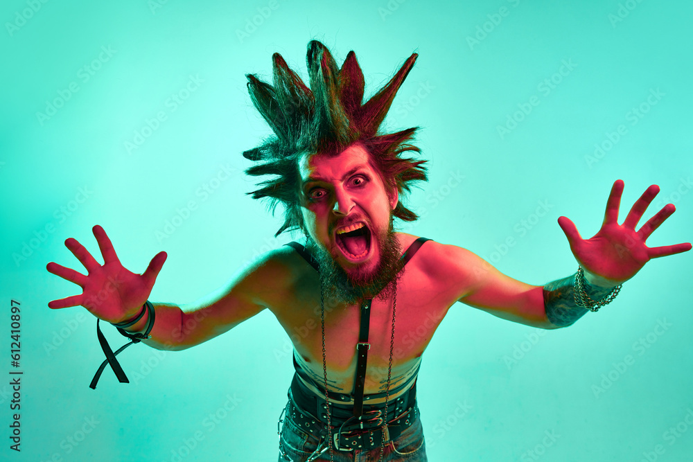 Portrait of young crazy looking man, punk with expressive hairstyle ...