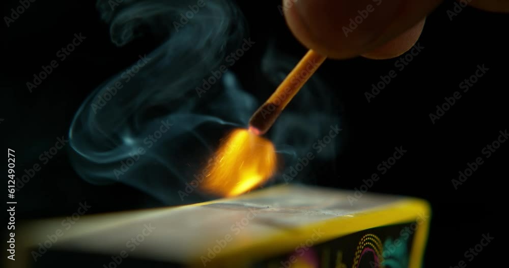 Match ignite, hand and orange flame with smoke and smoking in studio ...