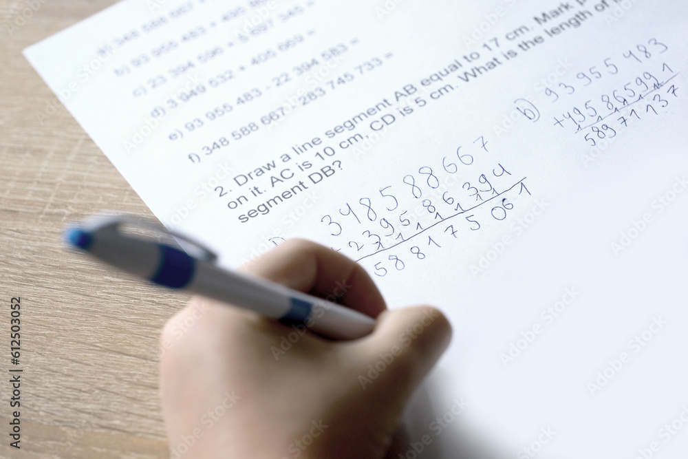 child, schoolchild hesitantly solves difficult task of adding numbers ...