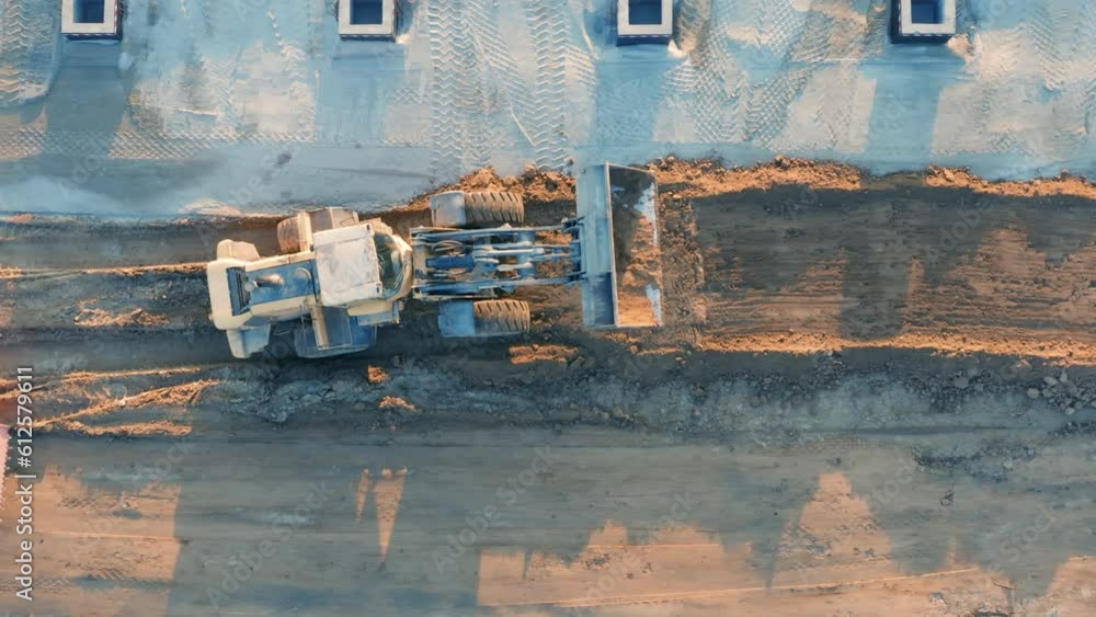 Aerial top down view of backhoe loader and asphalt paver (steam roller ...