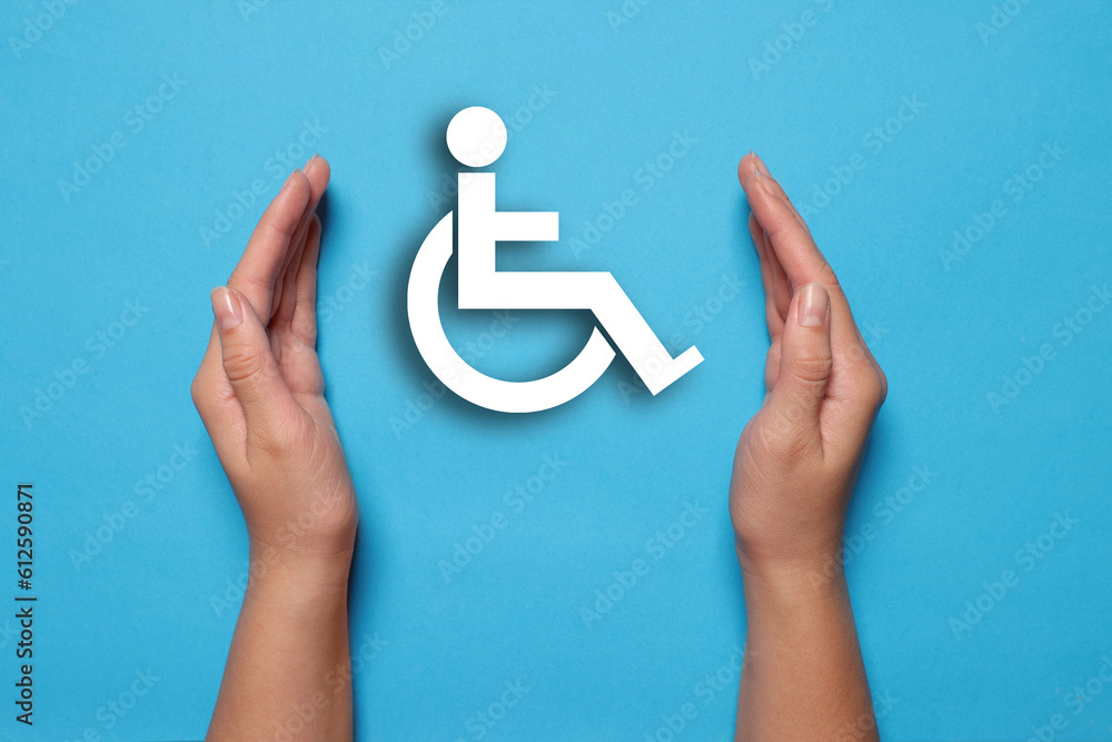 Disability inclusion. Woman protecting wheelchair symbol on light blue ...