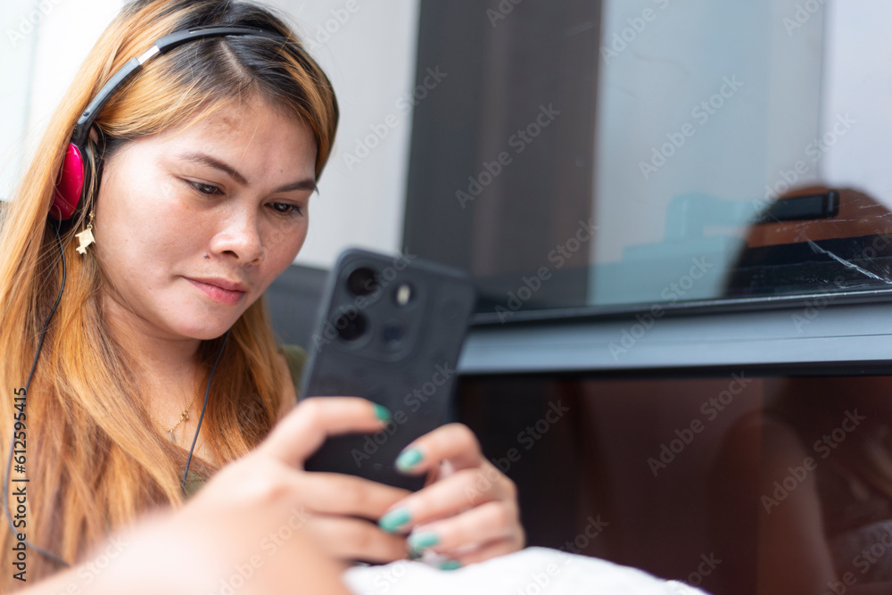 Young Filipina woman,on her smart phone,talking to her distant family ...