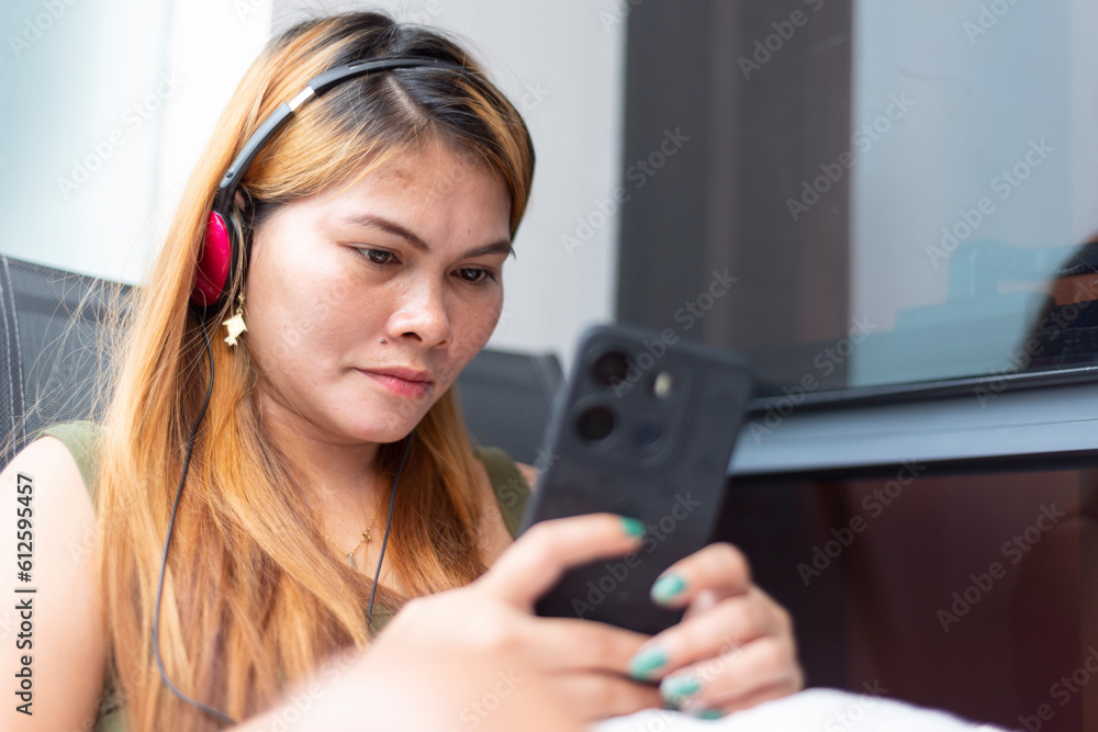 Young Filipina woman,on her smart phone,talking to her distant family ...
