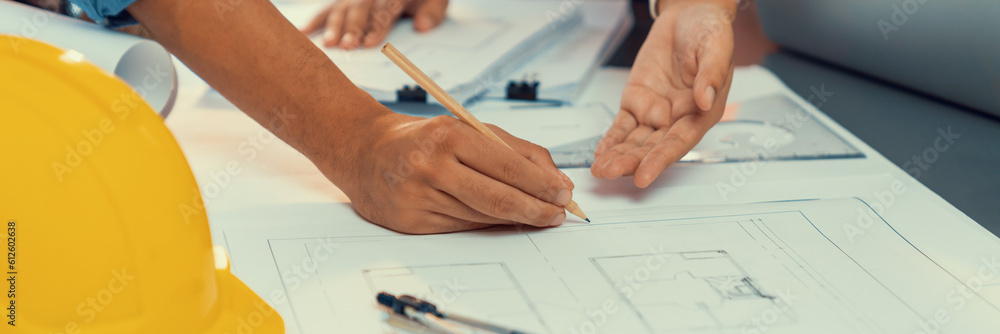 Engineer partner drawing and working on blueprint design together on ...