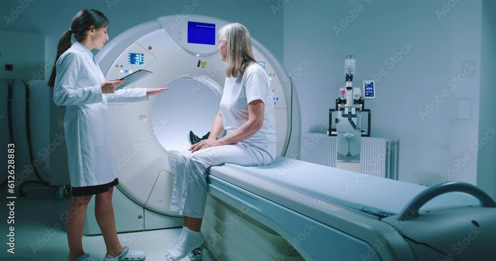 Zoom shooting. Female doctor talking to patient and points to MRI ...