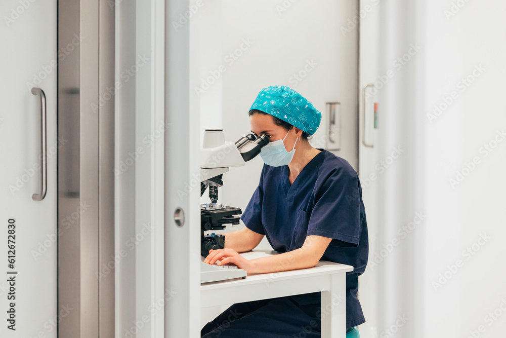 Biologist in uniform working using microscope in fertility lab Stock ...