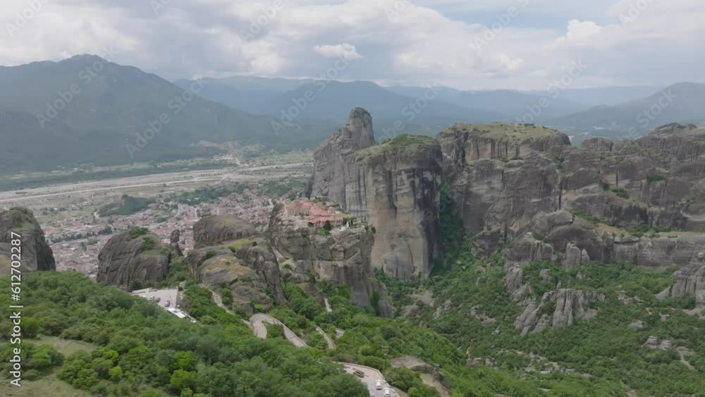 Wide aerial arcing shot of Holy Trinity monastery atop rock column ...
