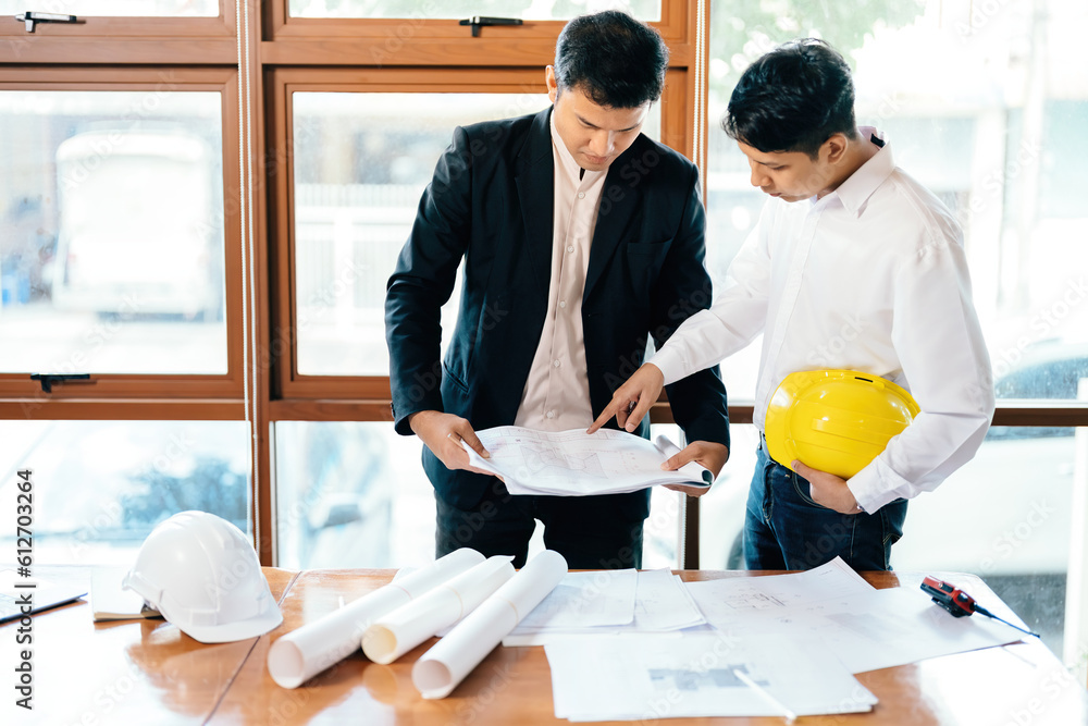 Two Asian male architects are meeting for a structural engineering ...