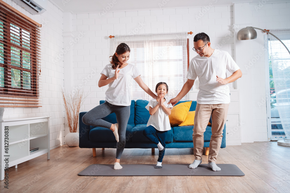 Family consisting of parents and daughters happily exercising together ...