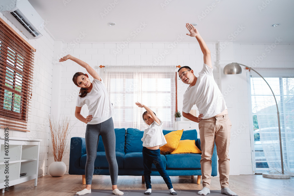 Family consisting of parents and daughters happily exercising together ...