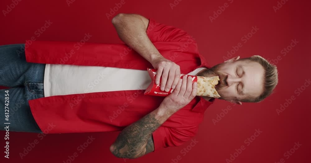 Vertical video of Unshaven caucasian man eats meat kebab with pleasure ...