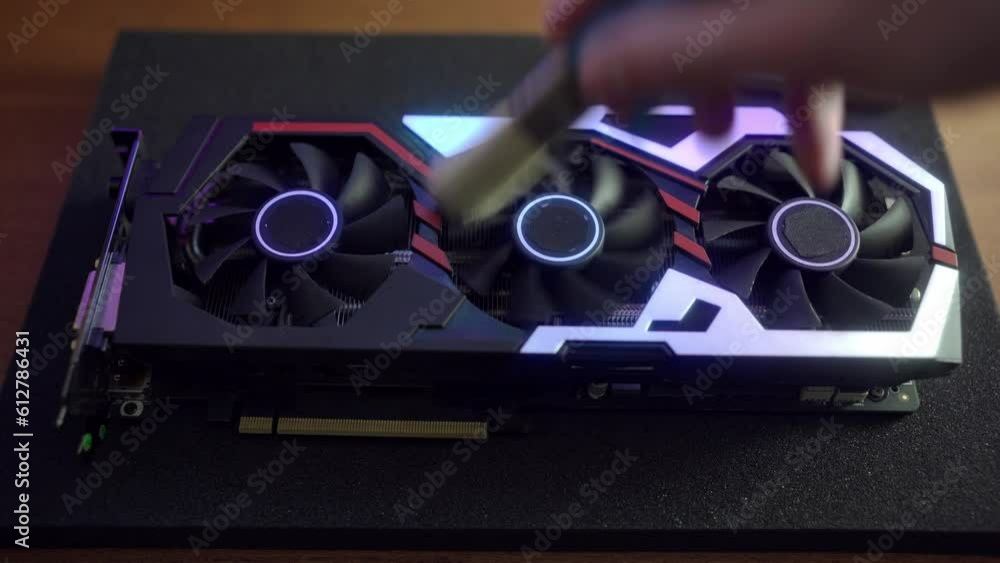 A computer technician takes apart a dirty video card to remove dust ...