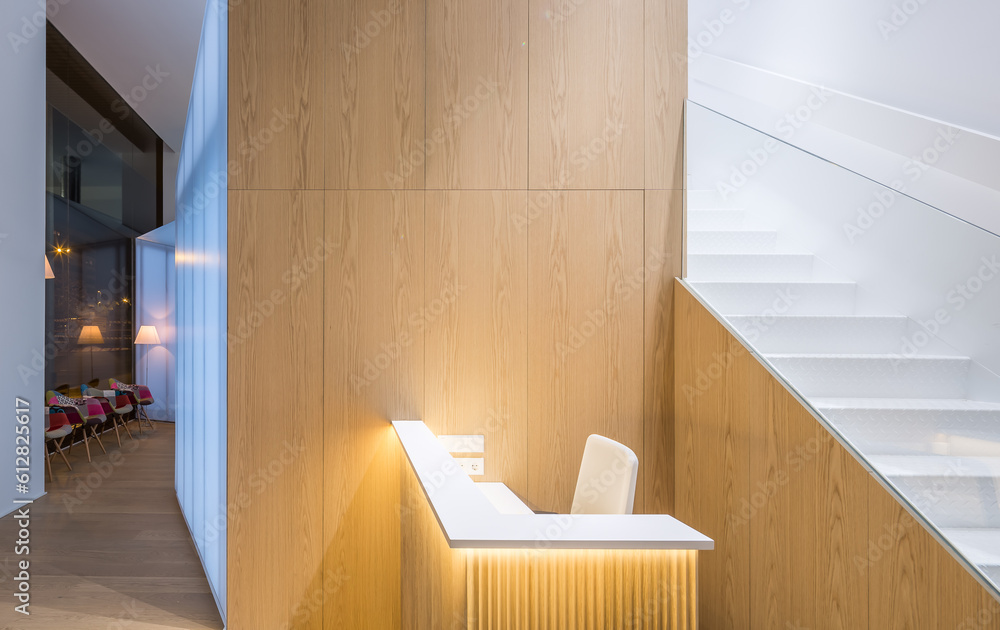 Lit reception desk and white steps in spacious building Stock ...