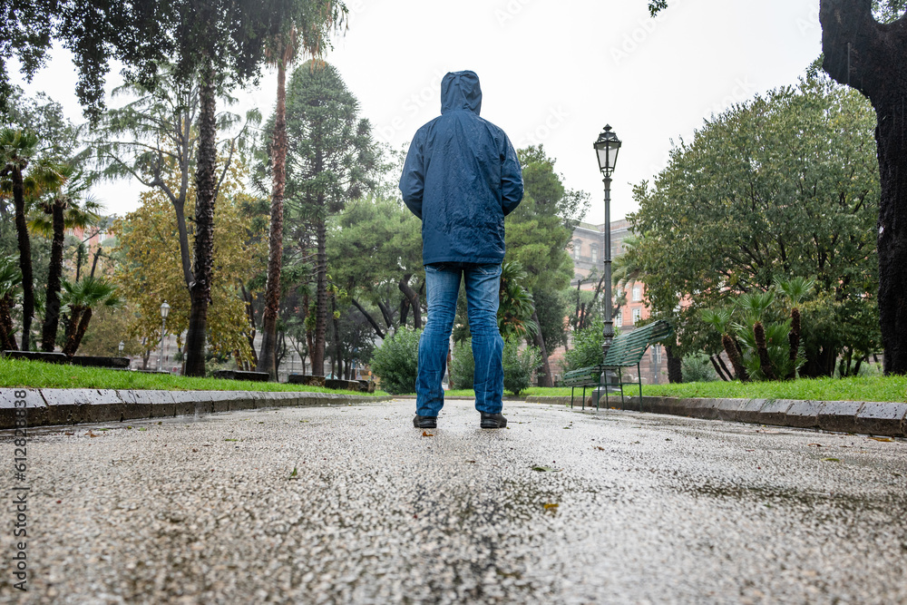 Foto de Man standing back to back in the rain in a city park. Autumn ...